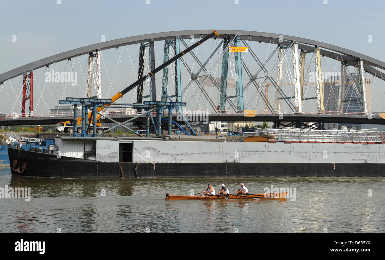 A rowing boat and a freighter go past the construction site of the new ...