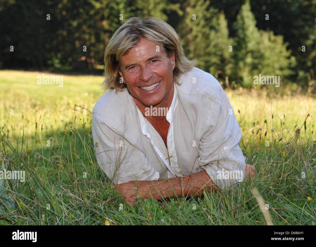 Hansi Hinterseer lies on a meadow during the presentation of his new ...
