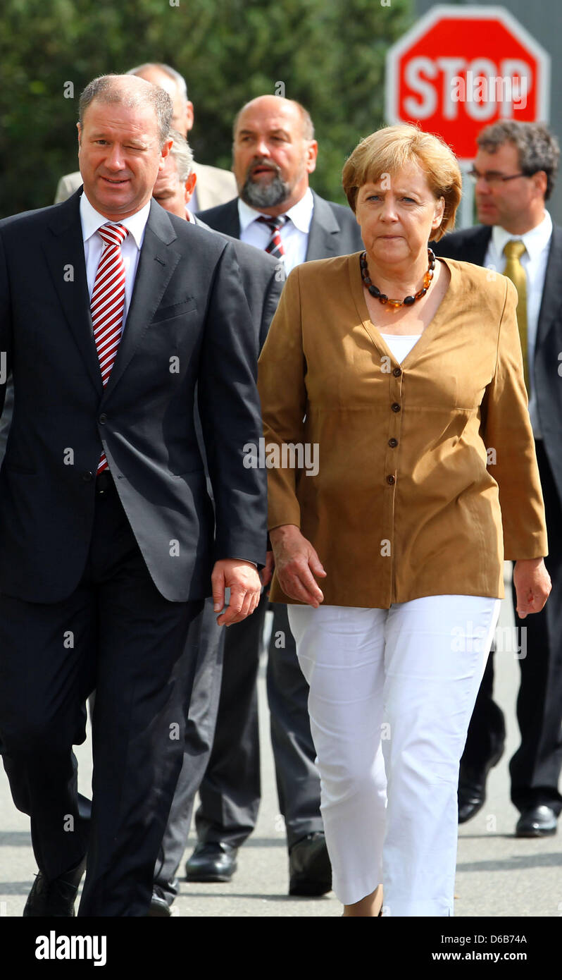 German Chancellor Angela Merkel and Wolgast Ruediger Fuchs (L) give a ...
