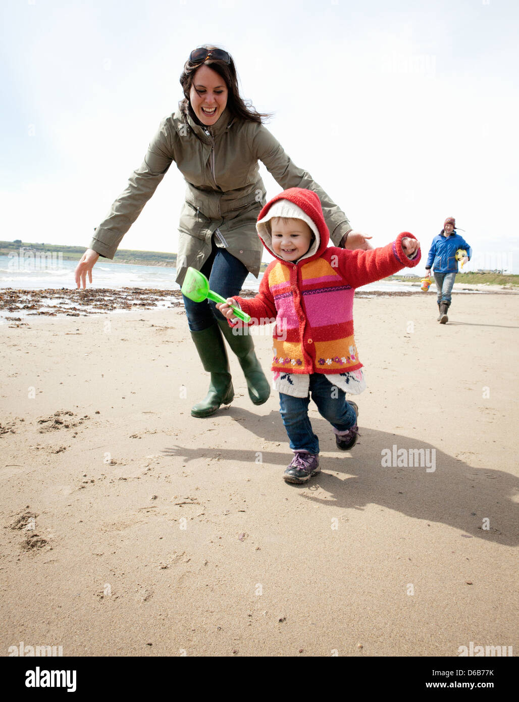 Mother chasing daughter on beach Stock Photo - Alamy