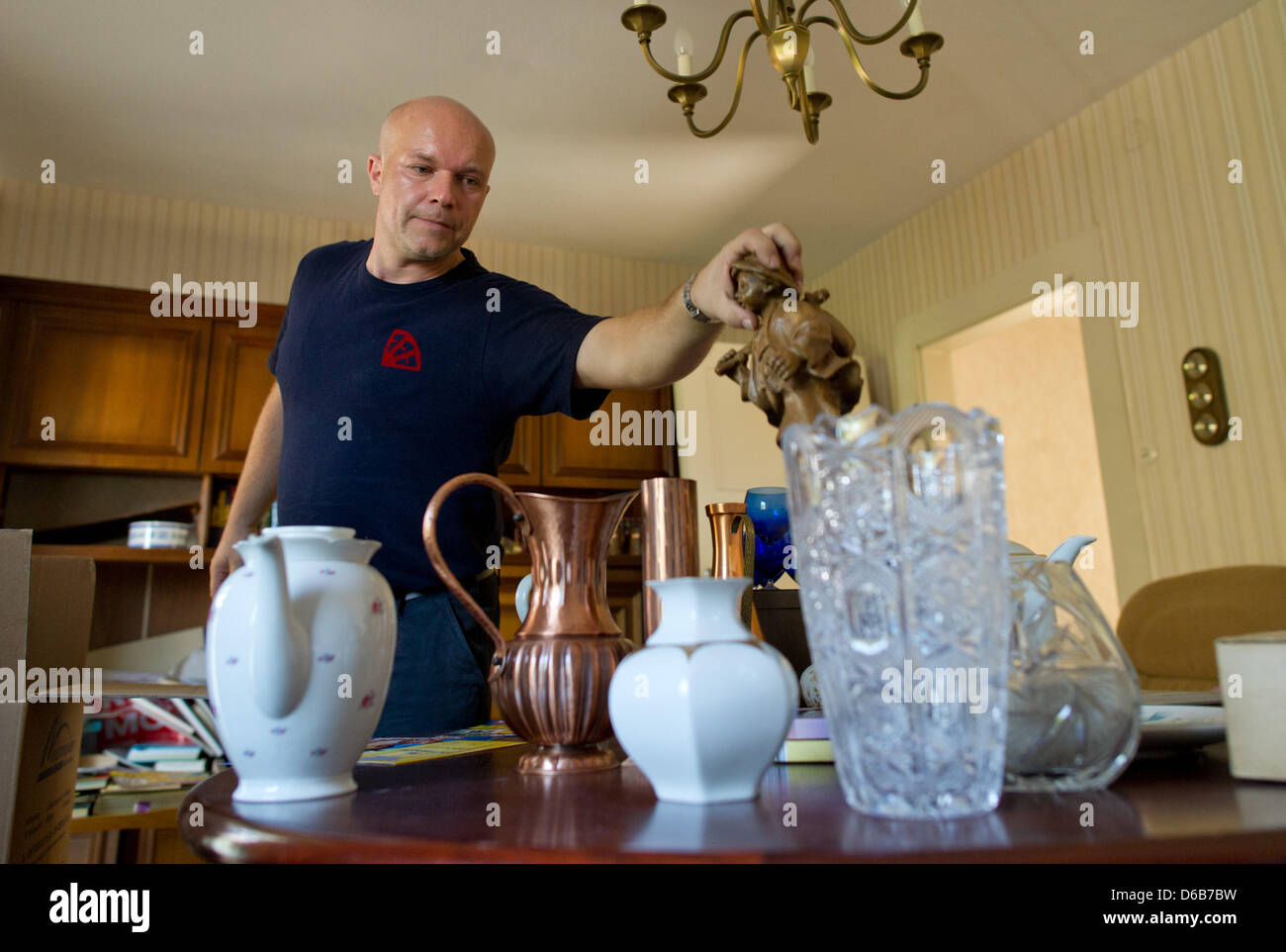 An employee from a house clearing company packs items into boxes in a ...