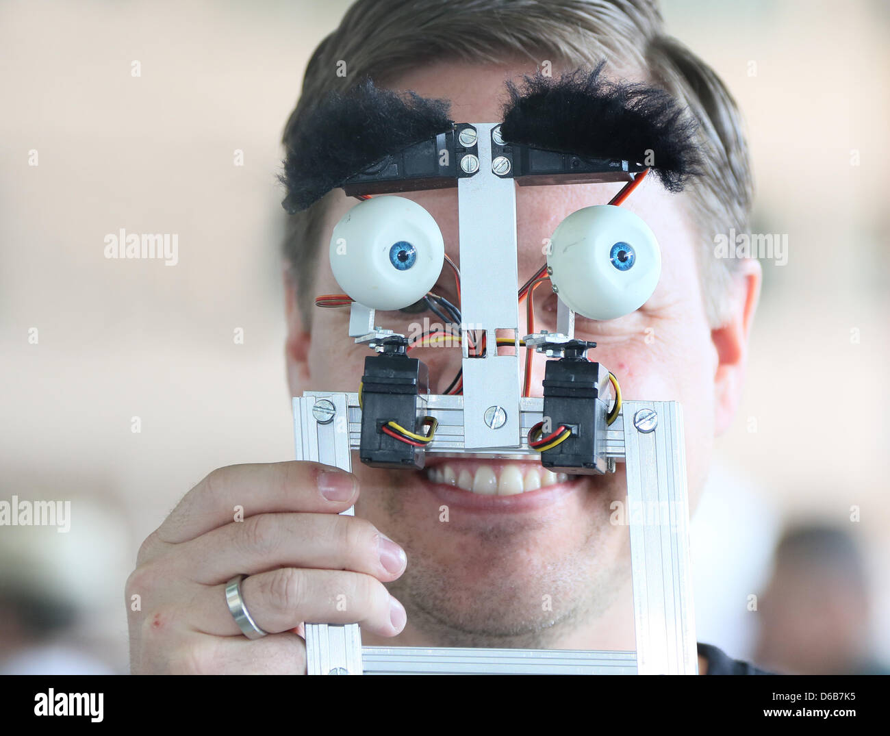 A man holds a self-made mechanical face at Campus Party Europe in ...