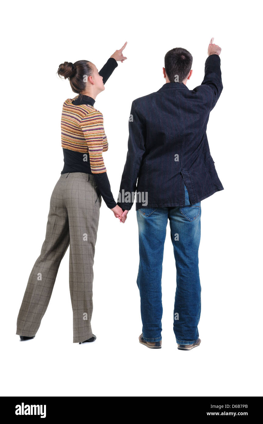 Young couple pointing at wall. Rear view. Isolated over white ...