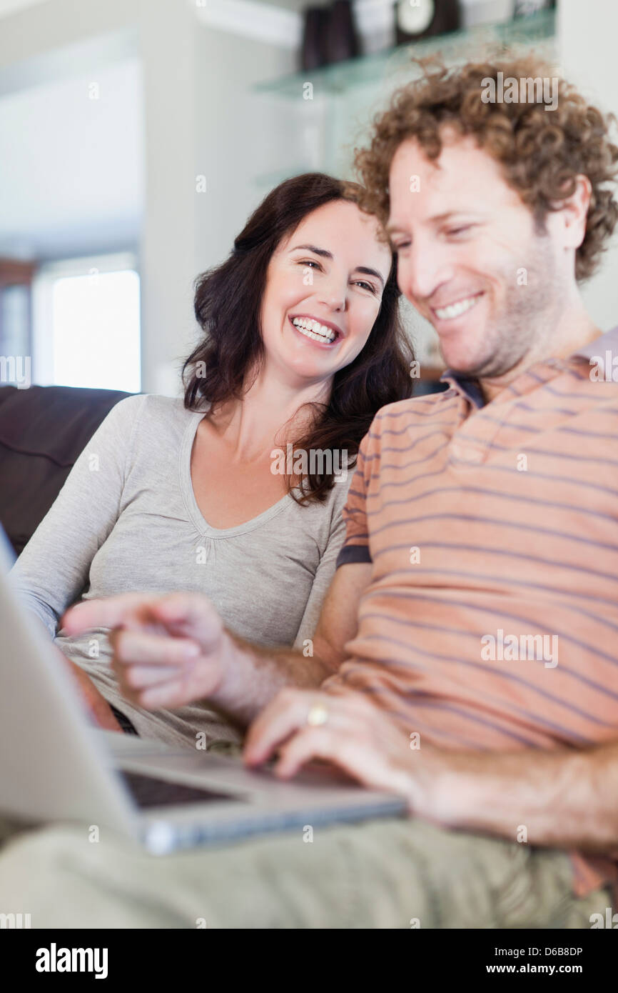 Couple using laptop together on sofa Stock Photo - Alamy