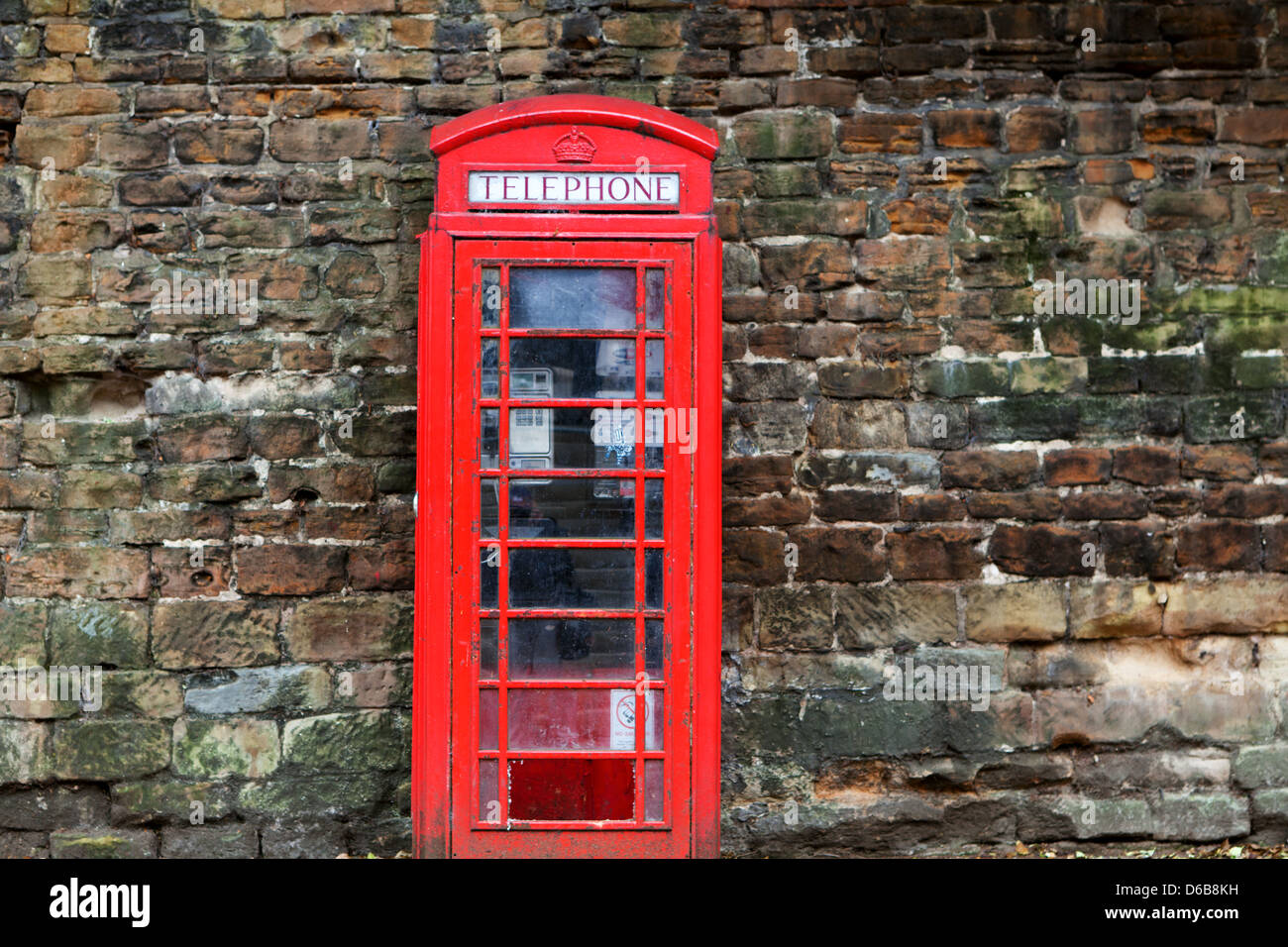 The British red phone booth on old wall Stock Photo - Alamy