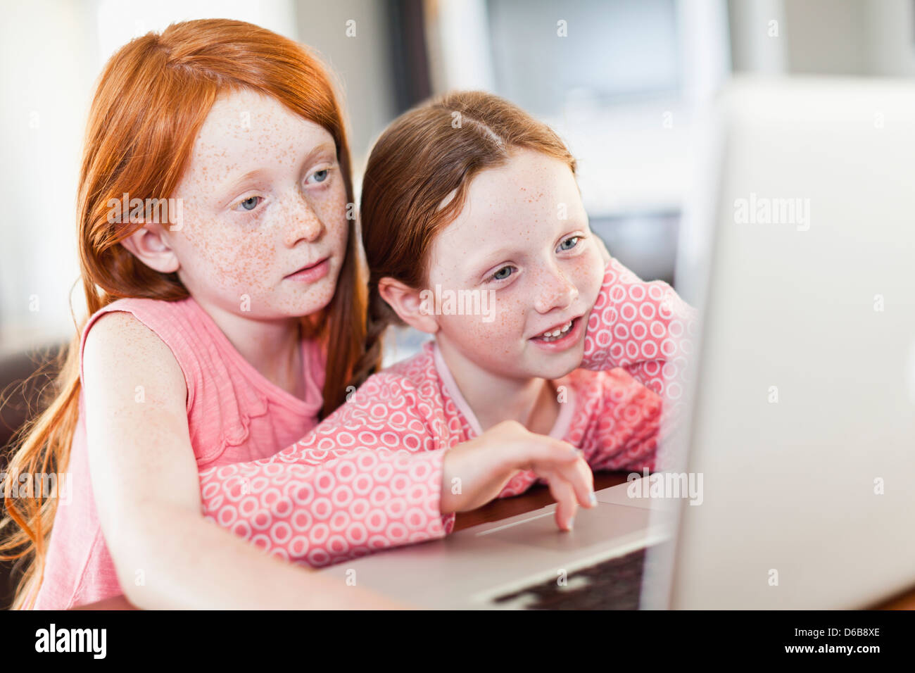 Girls using laptop together Stock Photo - Alamy