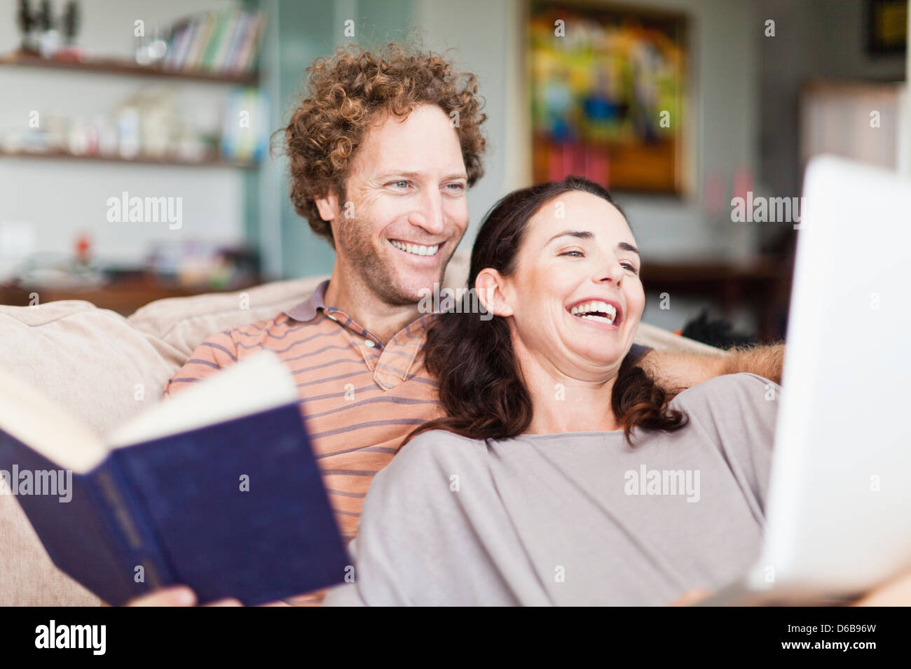Couple reading together on sofa Stock Photo - Alamy