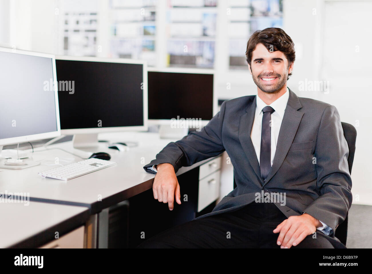 Businessman smiling at desk Stock Photo - Alamy