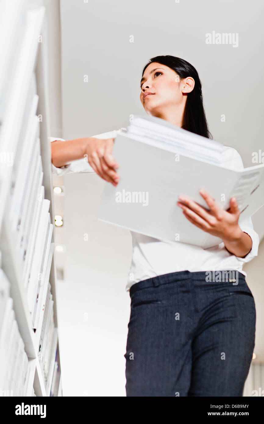 Serious young businesswoman holding folder hi-res stock photography and ...