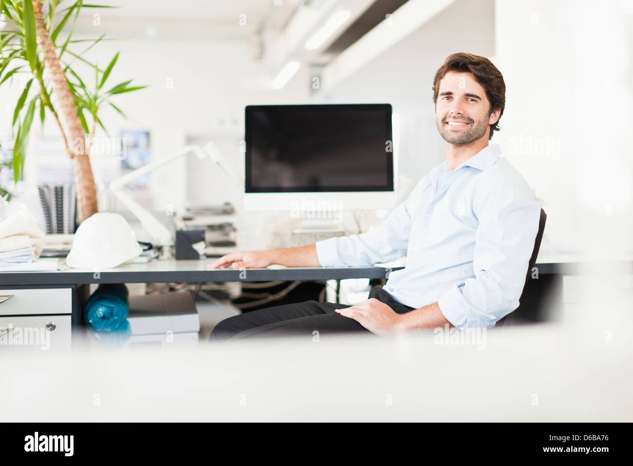 Businessman smiling at desk Stock Photo - Alamy