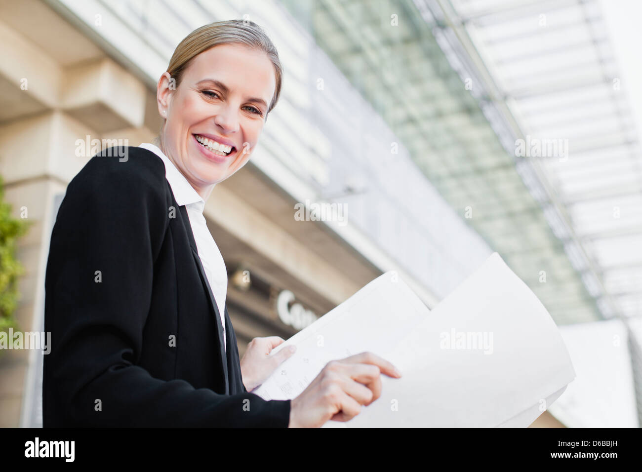Businesswoman reading blueprints Stock Photo - Alamy