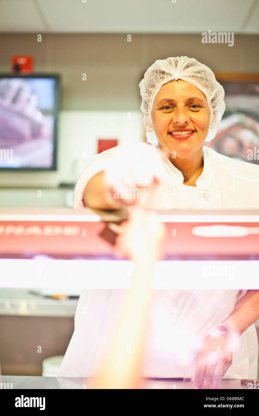 Butcher smiling at counter Stock Photo - Alamy