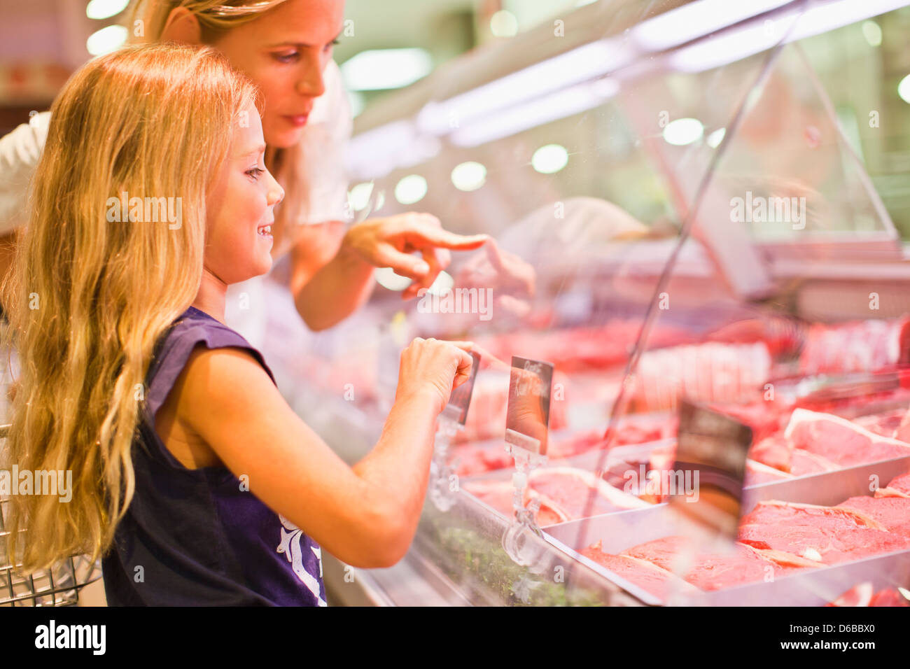 Mother and daughter at butcher counter Stock Photo - Alamy