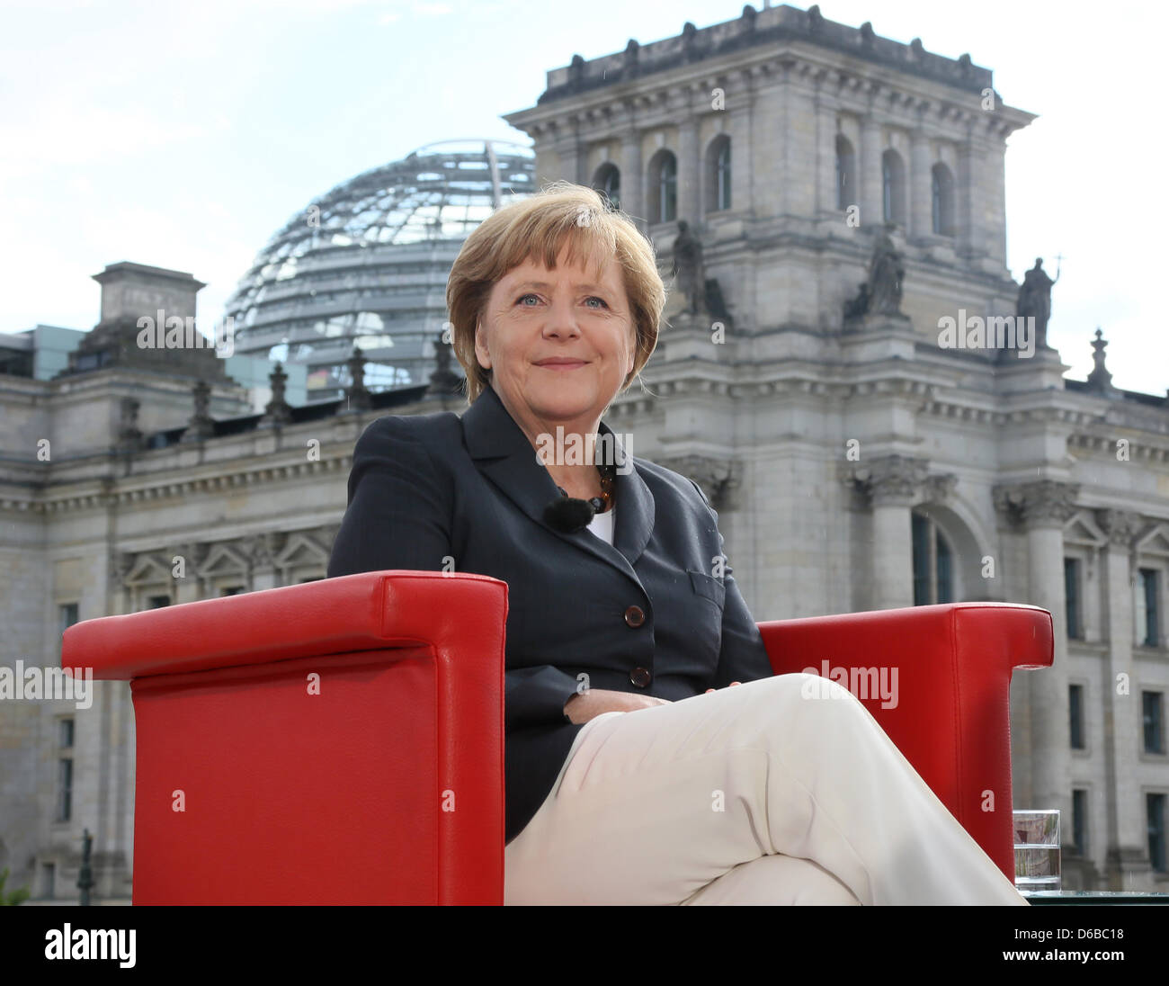 German Chancellor Angela Merkel sits on a red armchair during the ...