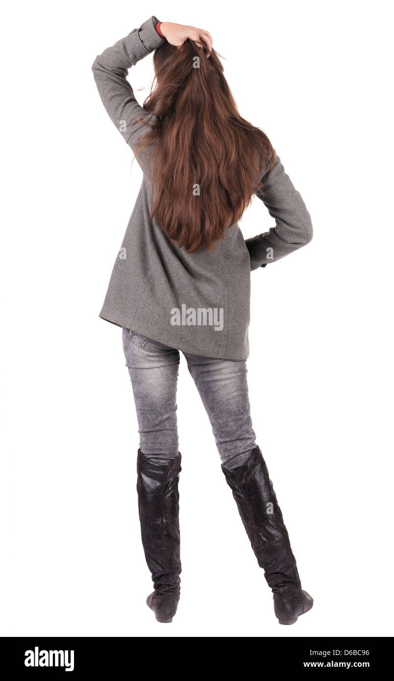 Back view of standing young beautiful woman. Brunette girl in jeans and ...