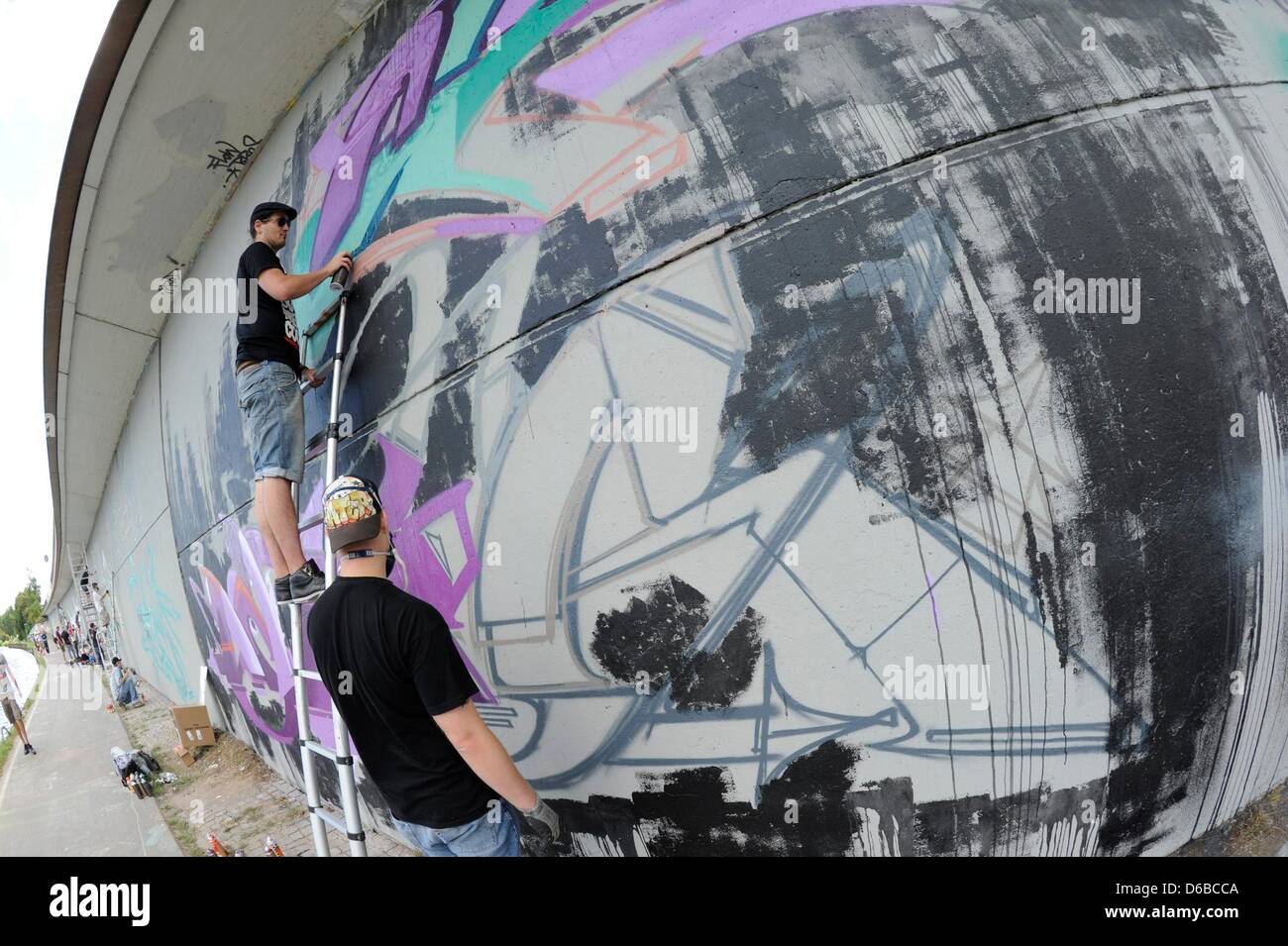 Artists spray graffitis on one of Germany's largest legal graffiti wall ...