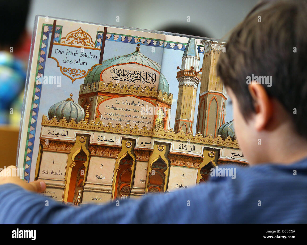 A boy reads a school book during the Islamic religious education lesson ...