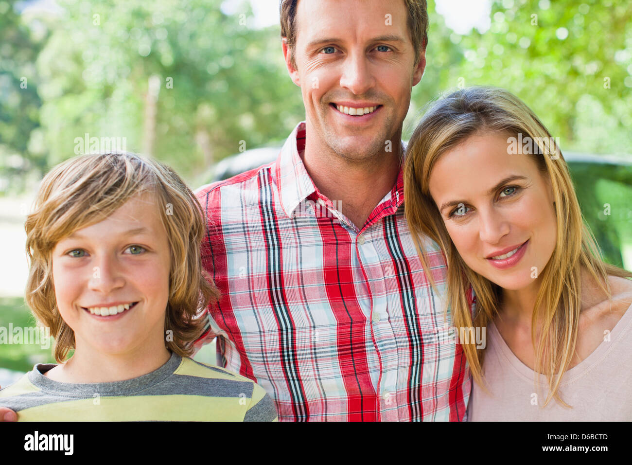 Family smiling together by car Stock Photo - Alamy