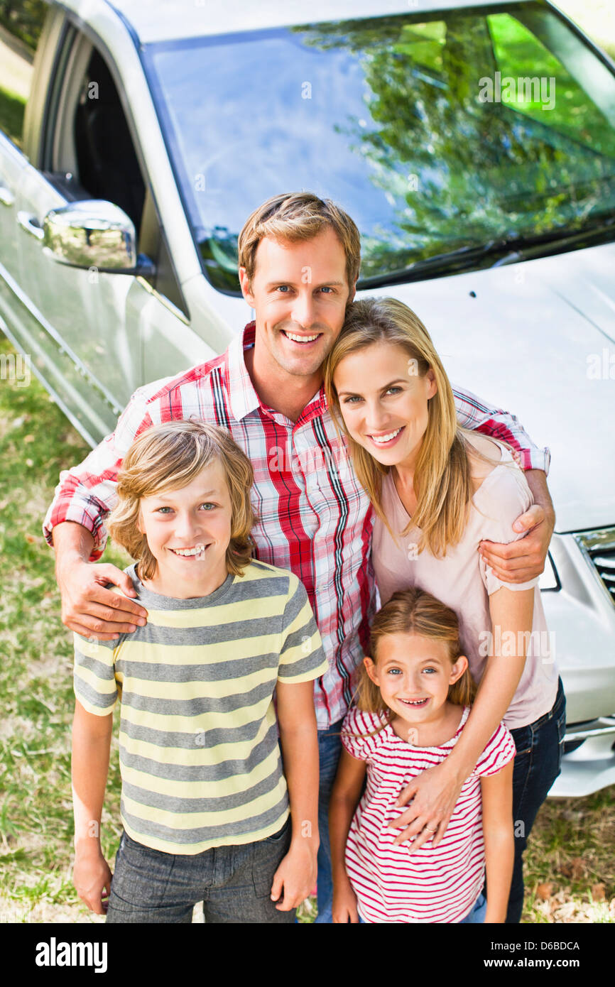 Family smiling together by car Stock Photo - Alamy