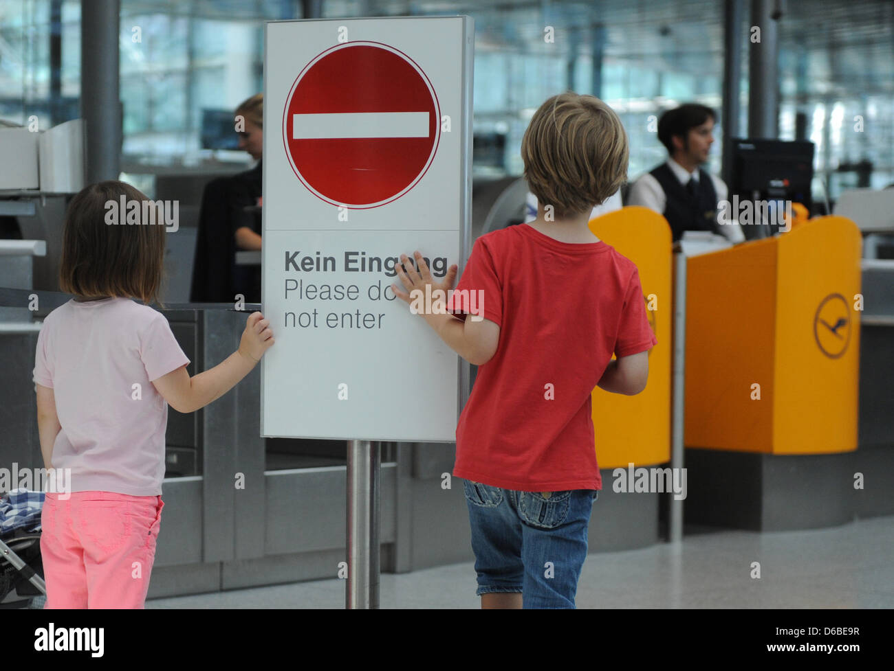 Two children stand next to a 'Do Not Enter Sign' in front of the check ...