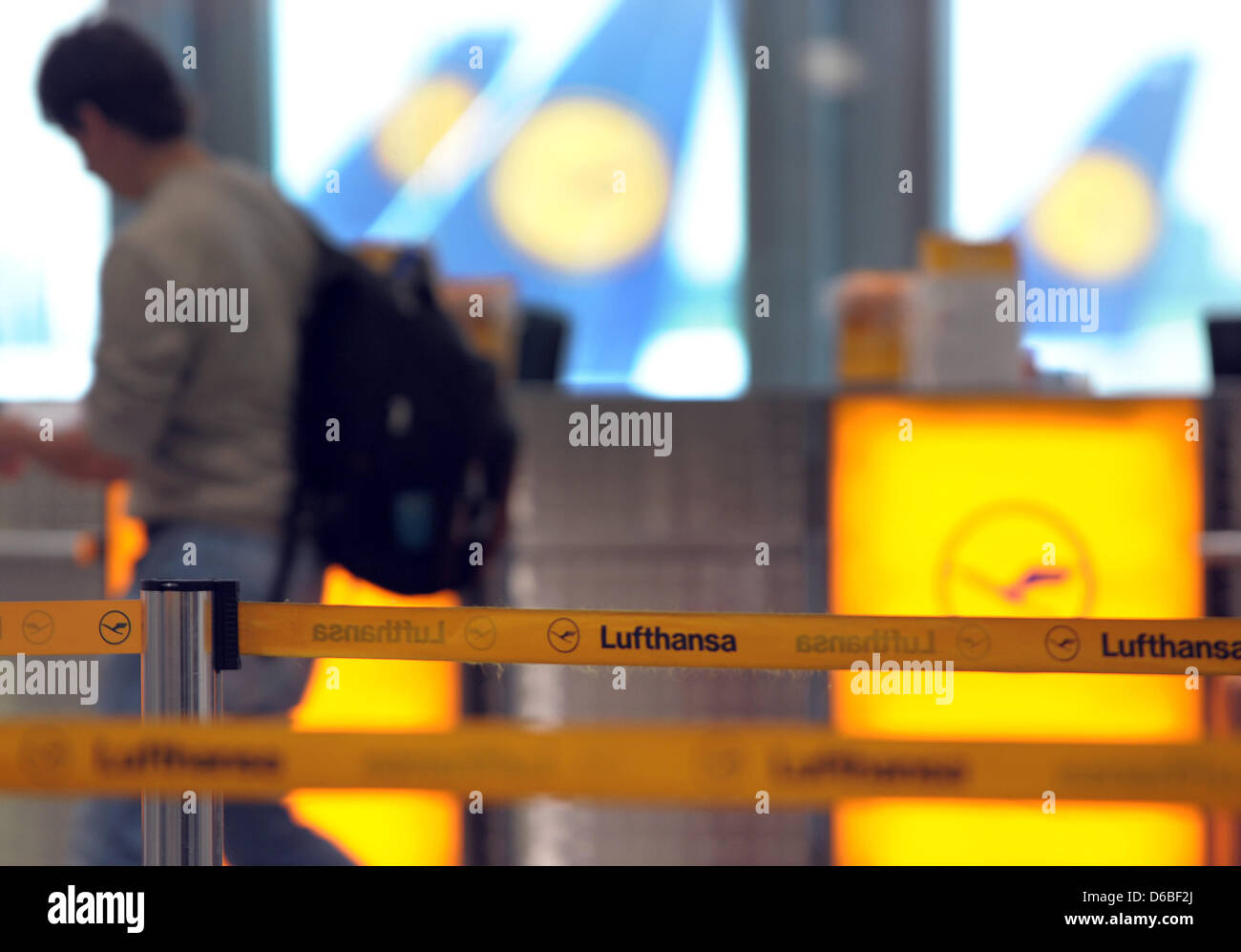 Travellers wait to check in at the Lufthansa counter at the airport in ...