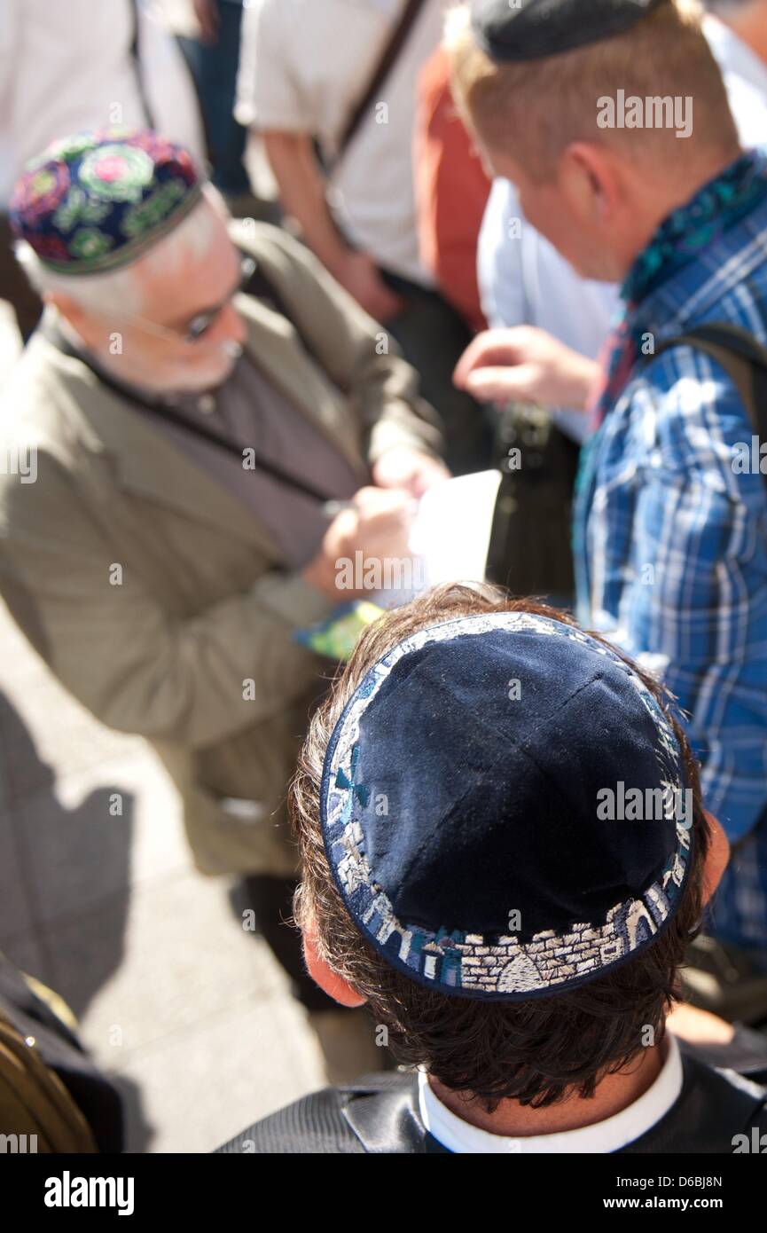 People walk along the streets wearing kippahs during a kippah flash mob ...