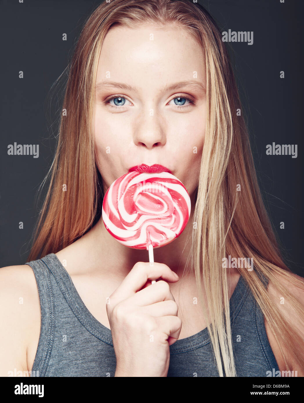 Smiling woman eating lollipop Stock Photo - Alamy
