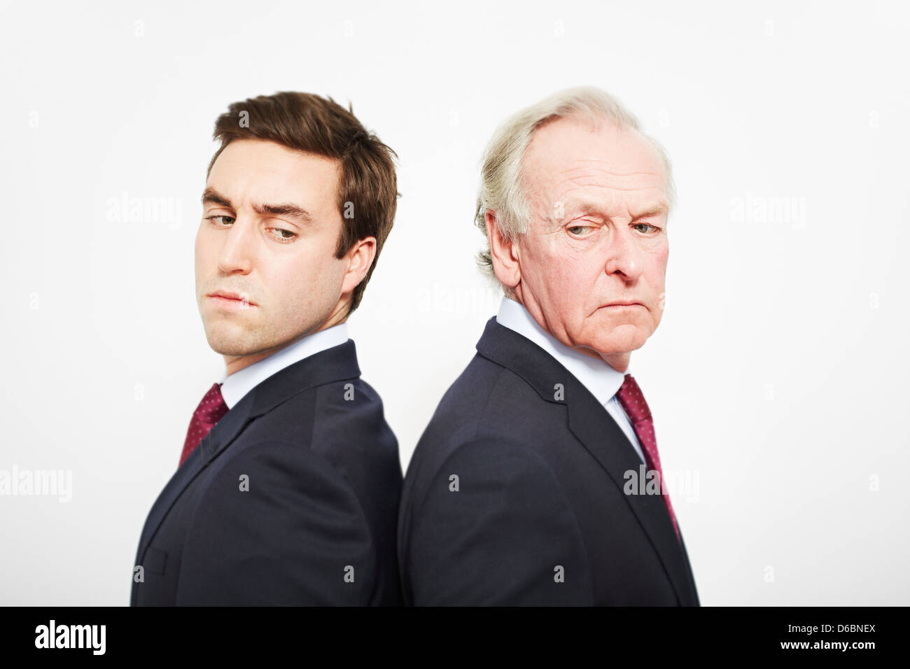 Businessmen standing back to back Stock Photo - Alamy