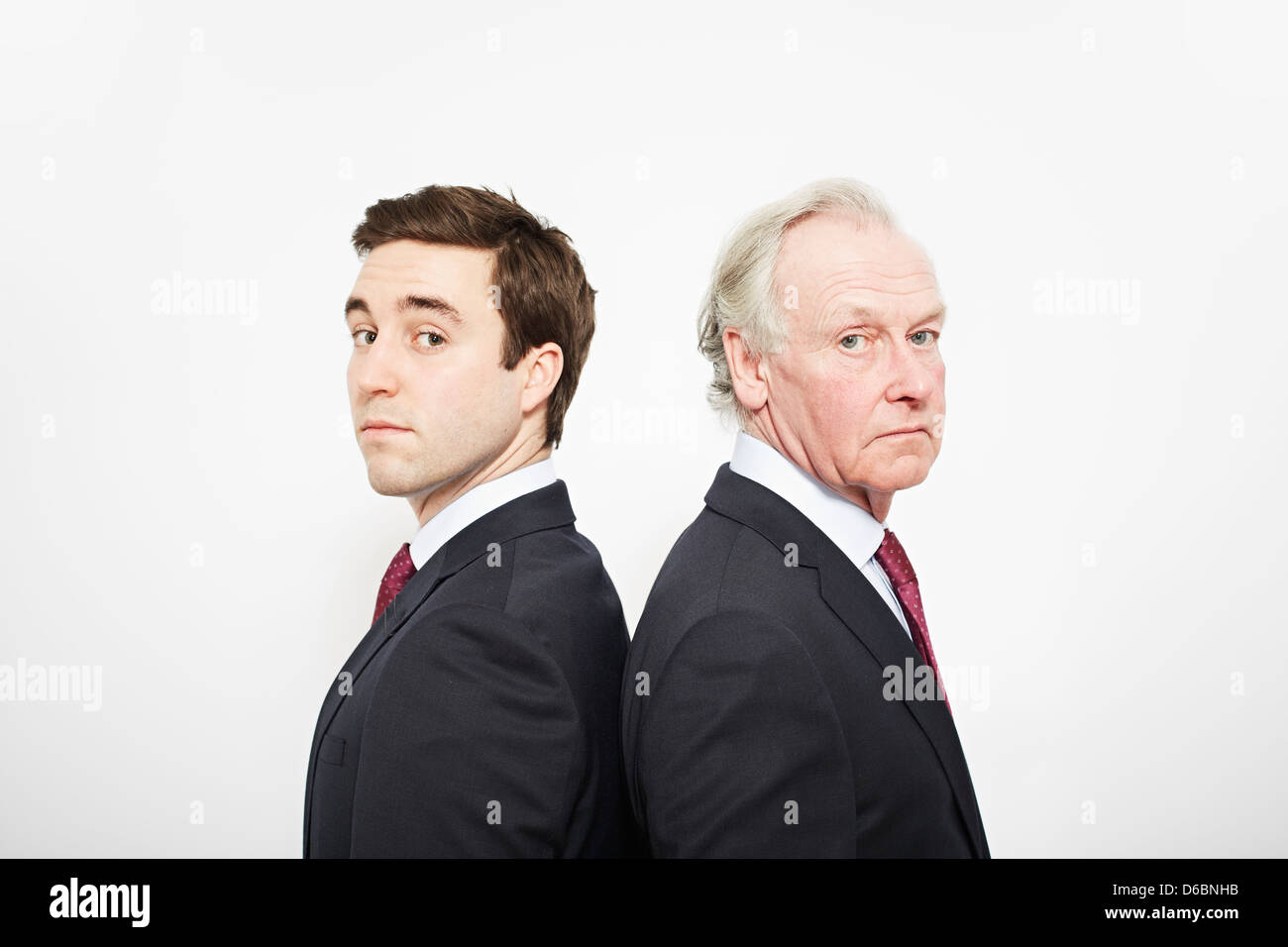 Businessmen standing back to back Stock Photo - Alamy