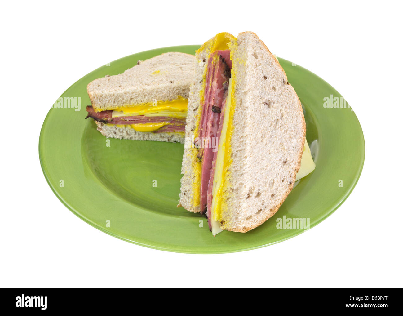 A cut prosciutto and Swiss cheese sandwich on rye bread with mustard on ...