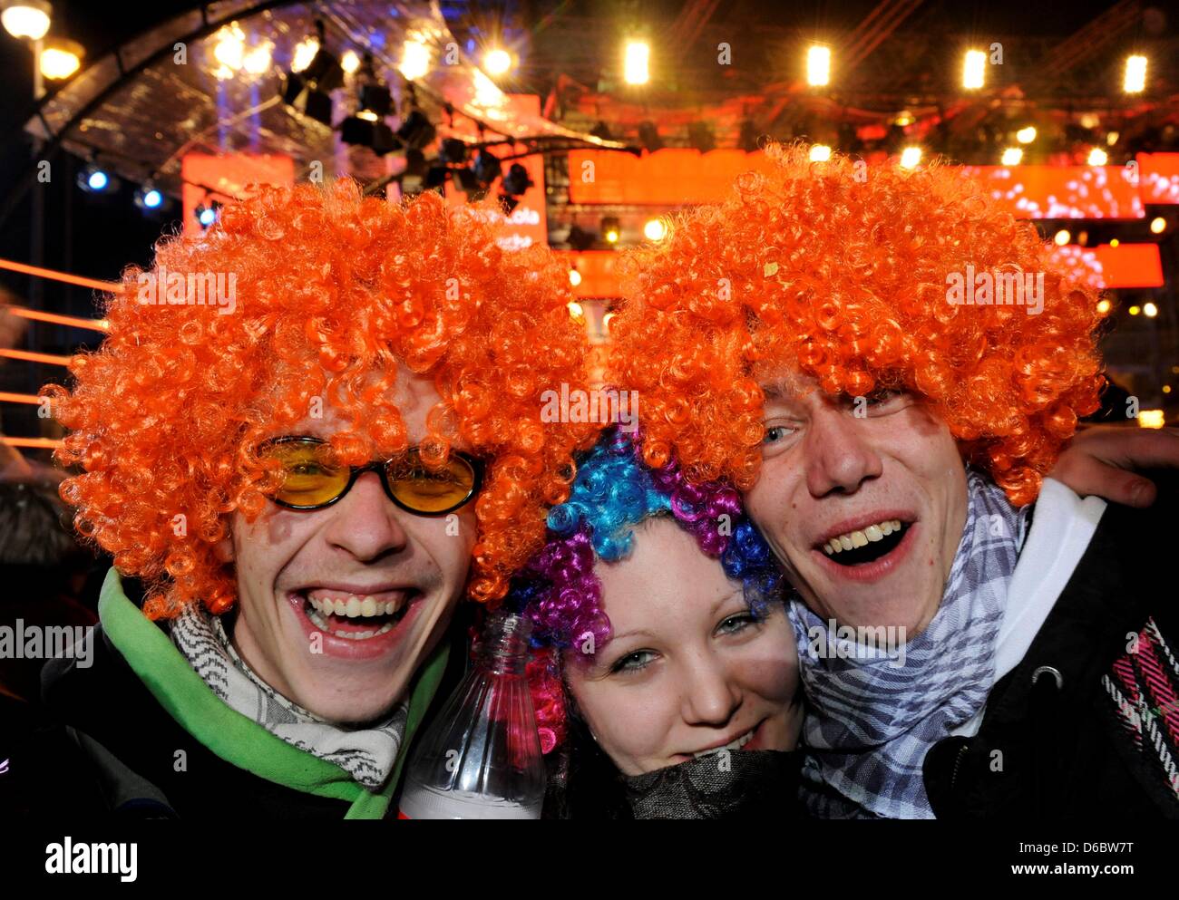 Three youths wearing wigs celebrate New Year's Eve at the Brandenburg ...