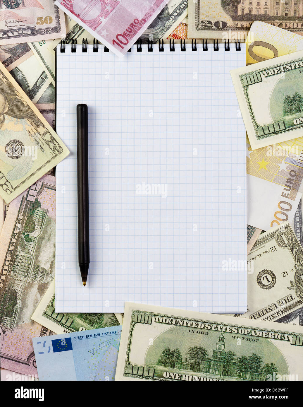 Opened spiral notepad (notebook) sheet in a cage on money background ...