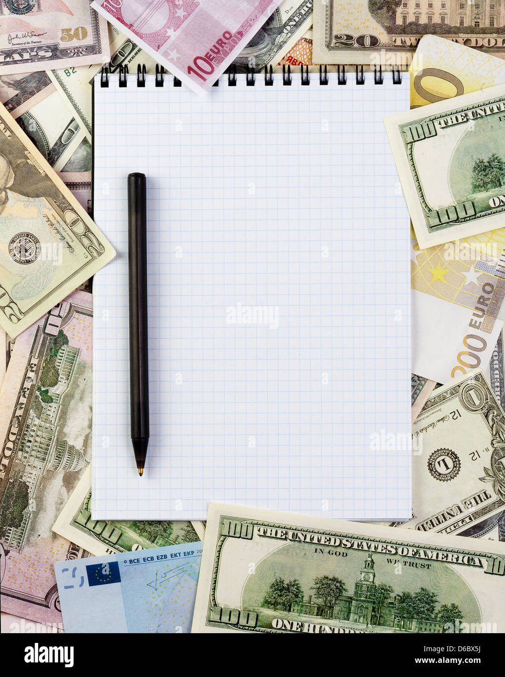 Opened spiral notepad (notebook) sheet in a cage on money background ...