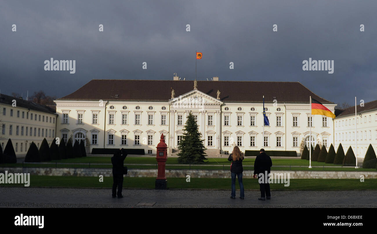 Tourists stand in front of the official residence of the German ...