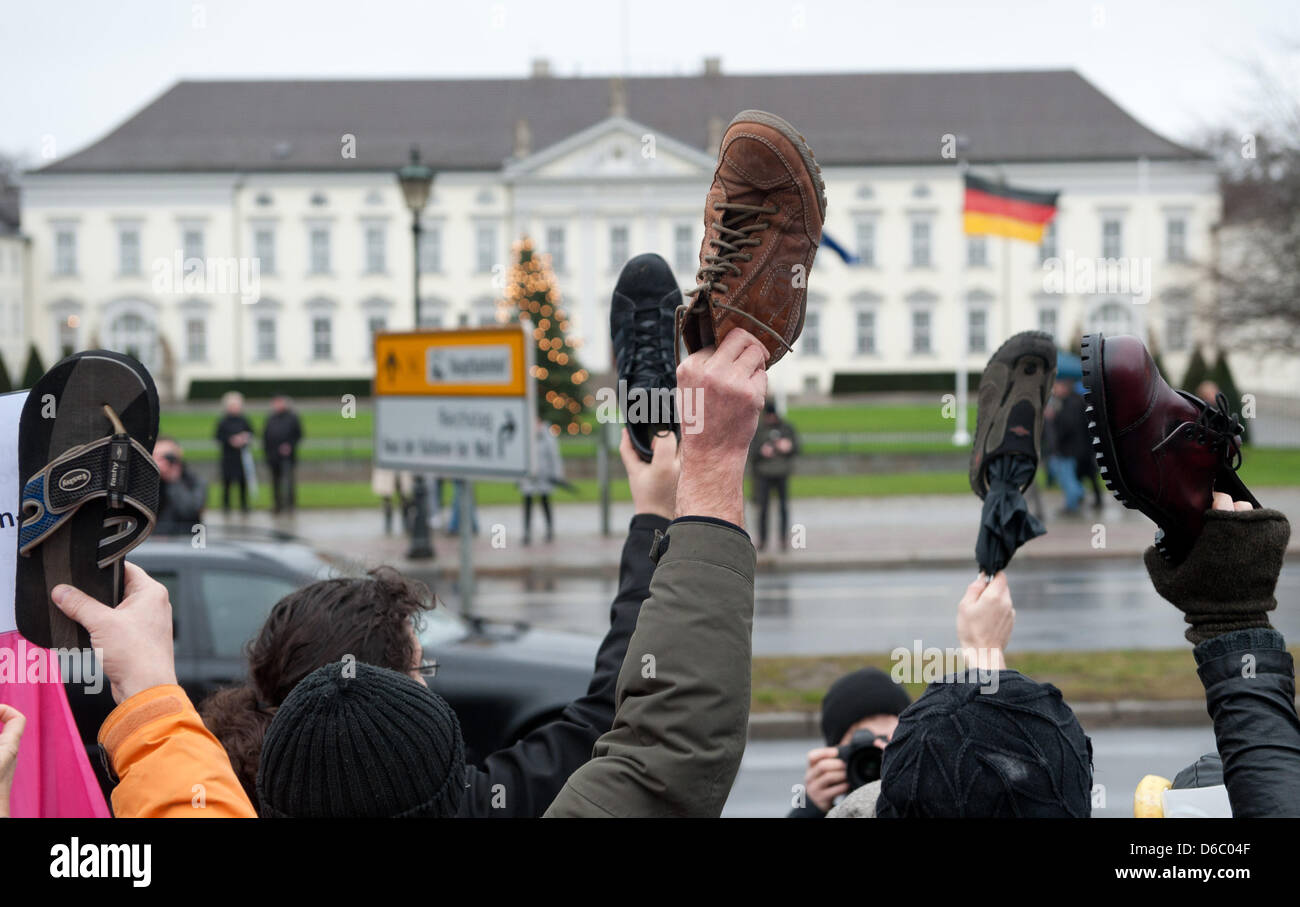 Protesters hold up shoes across the street from the official residence ...