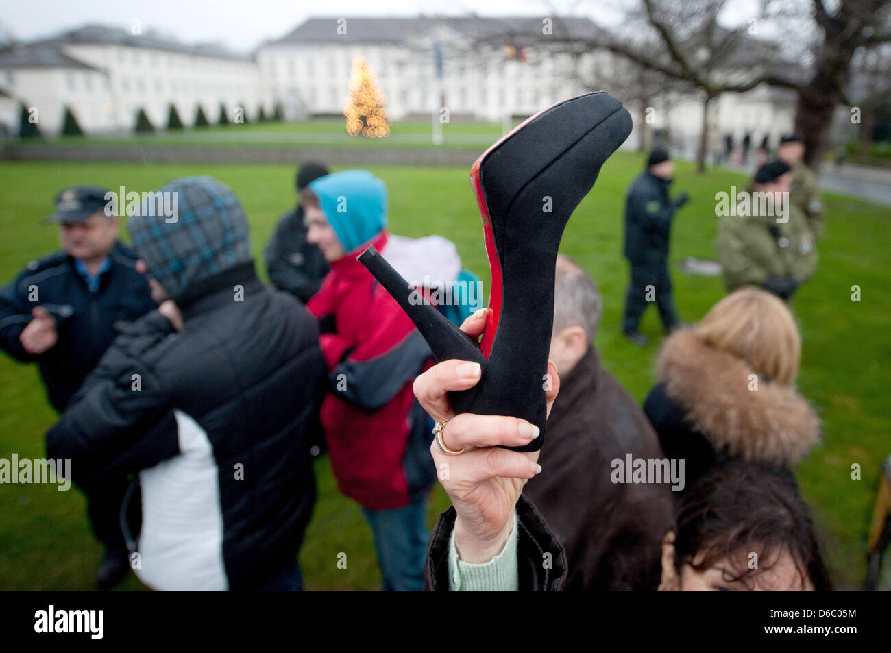 Protesters hold up shoes across the street from the official residence ...