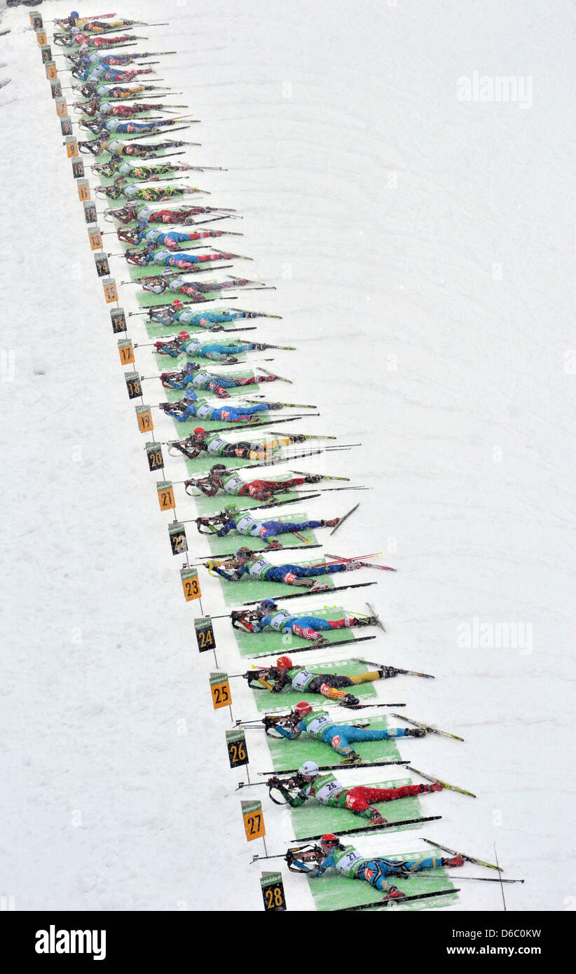 Biathletes lie at the shooting range during the women's 12.5 kilometres ...