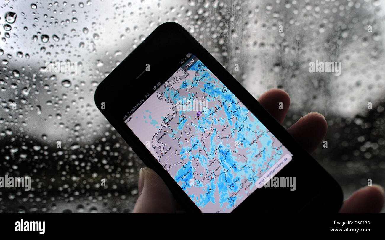 A smartphone shows a weather app forecasting rain in whole Germany in ...