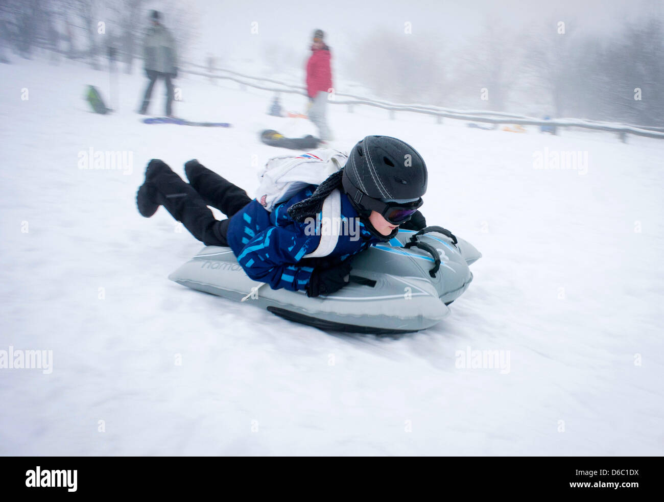 A boy on an inflatable sledge slides down the slope at the Grosser ...