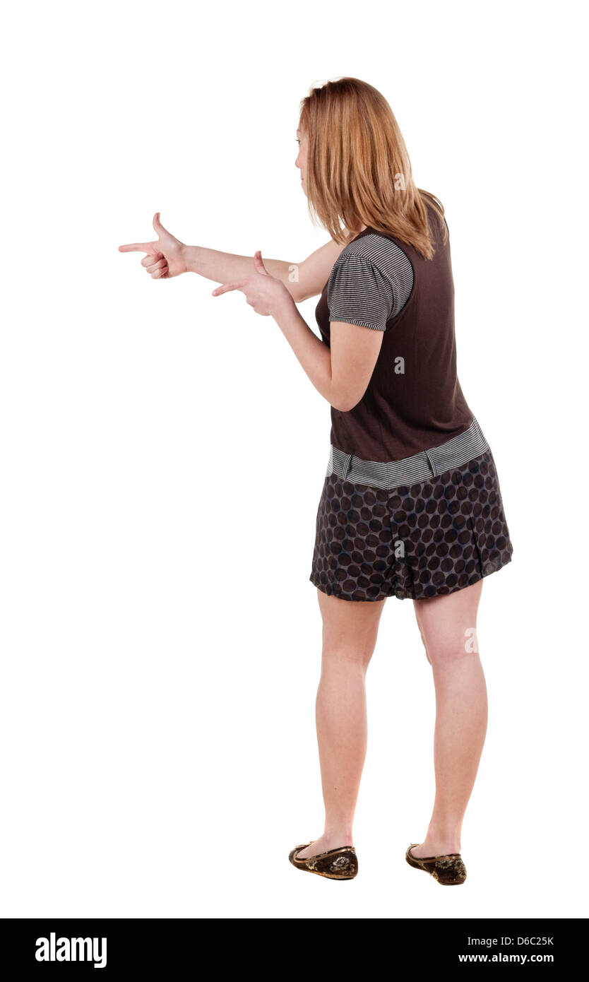 Back view of young blonde woman pointing at wall. Beautiful girl in ...