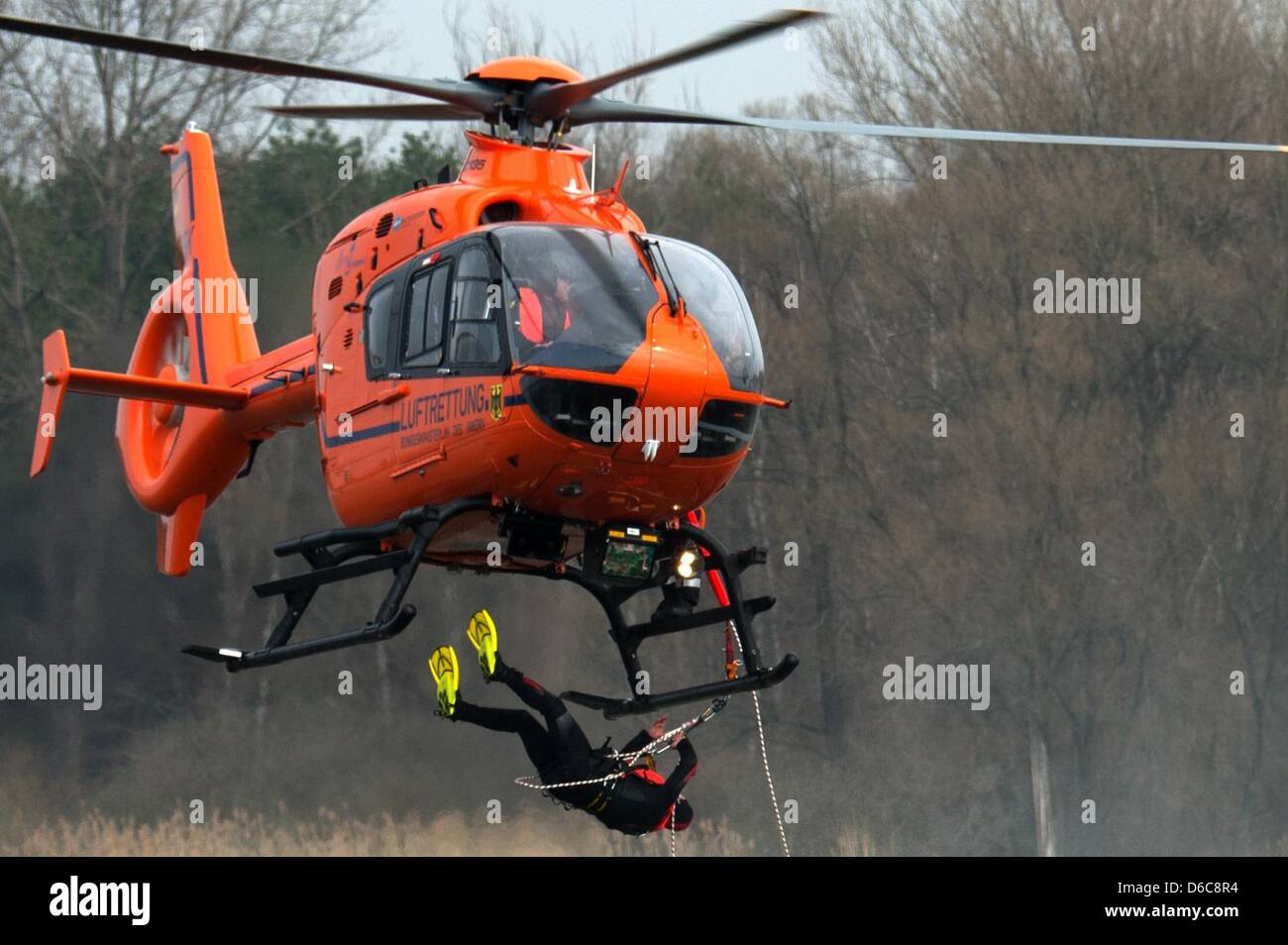 Firemen practice rescuing a person from the water with a helicopter ...