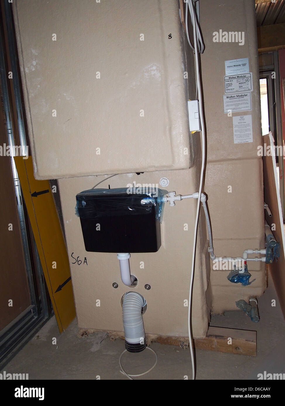 The back sides of a toilet pod unit as used to speed construction in ...