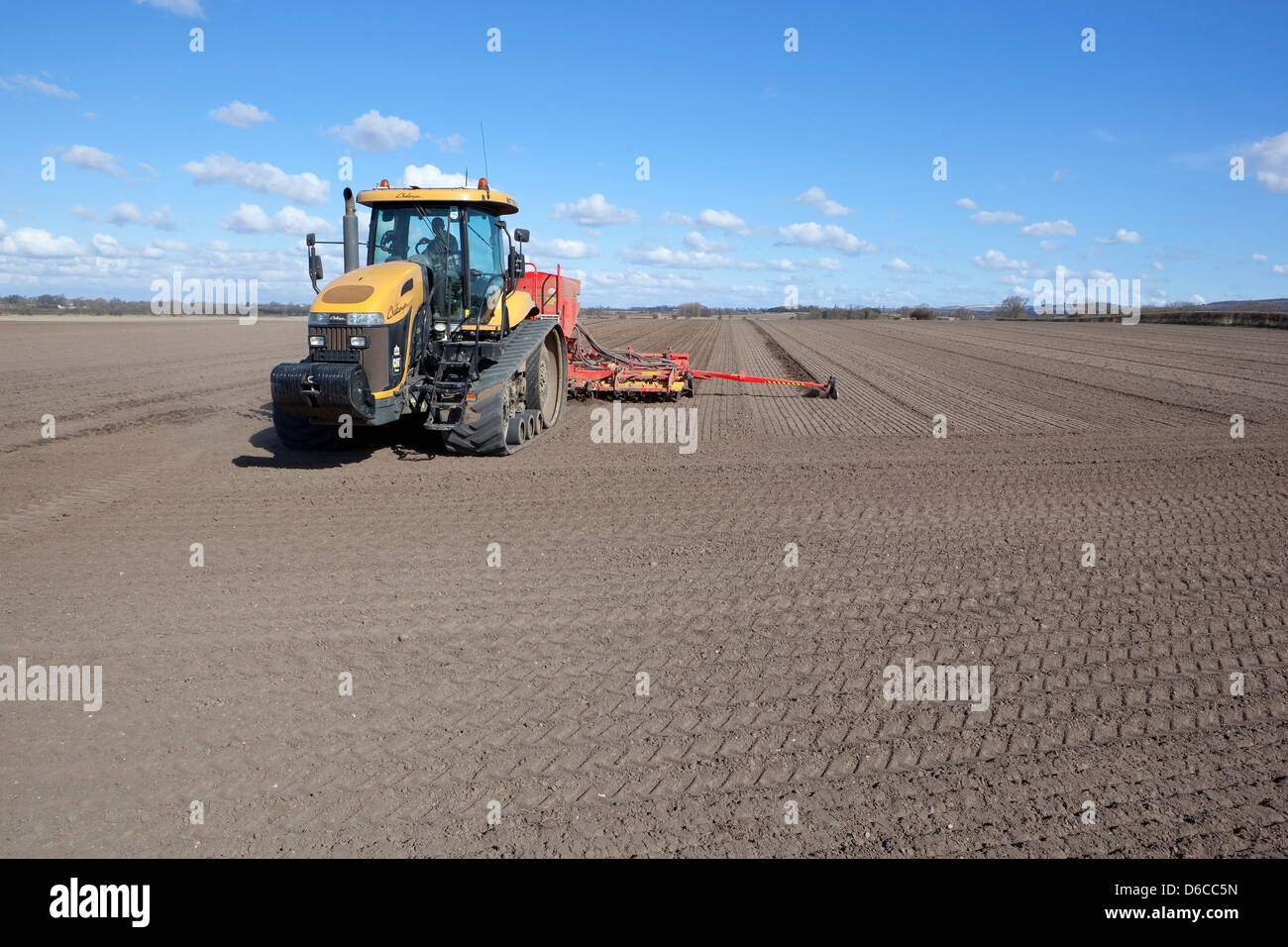 Arable agriculture with a tractor working in the cultivated soil of a ...