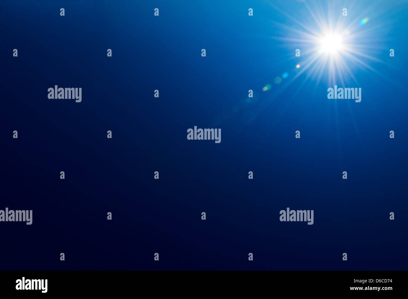 Bright sun on a deep blue background Stock Photo - Alamy