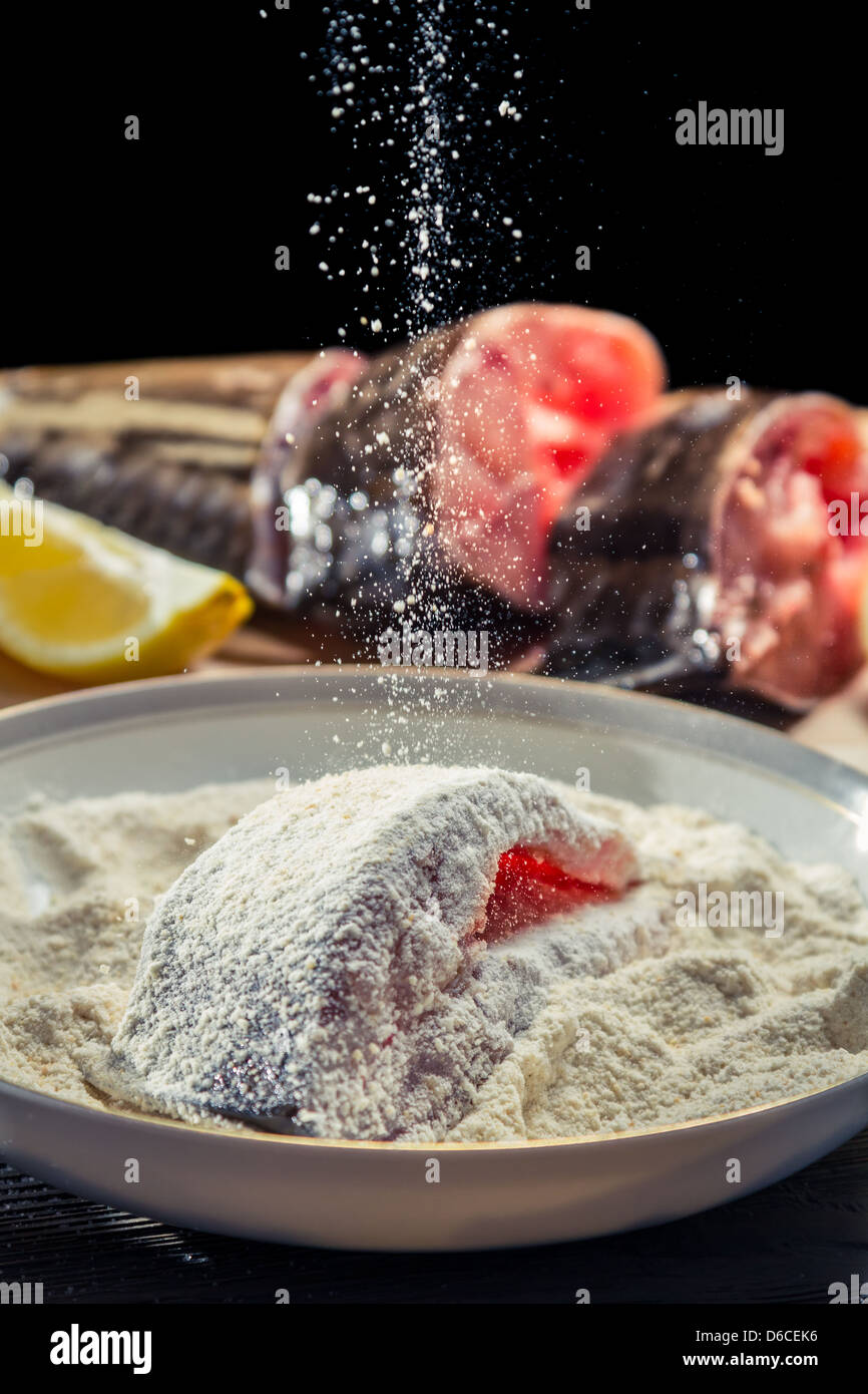 Fresh fish sprinkled flour before frying Stock Photo - Alamy