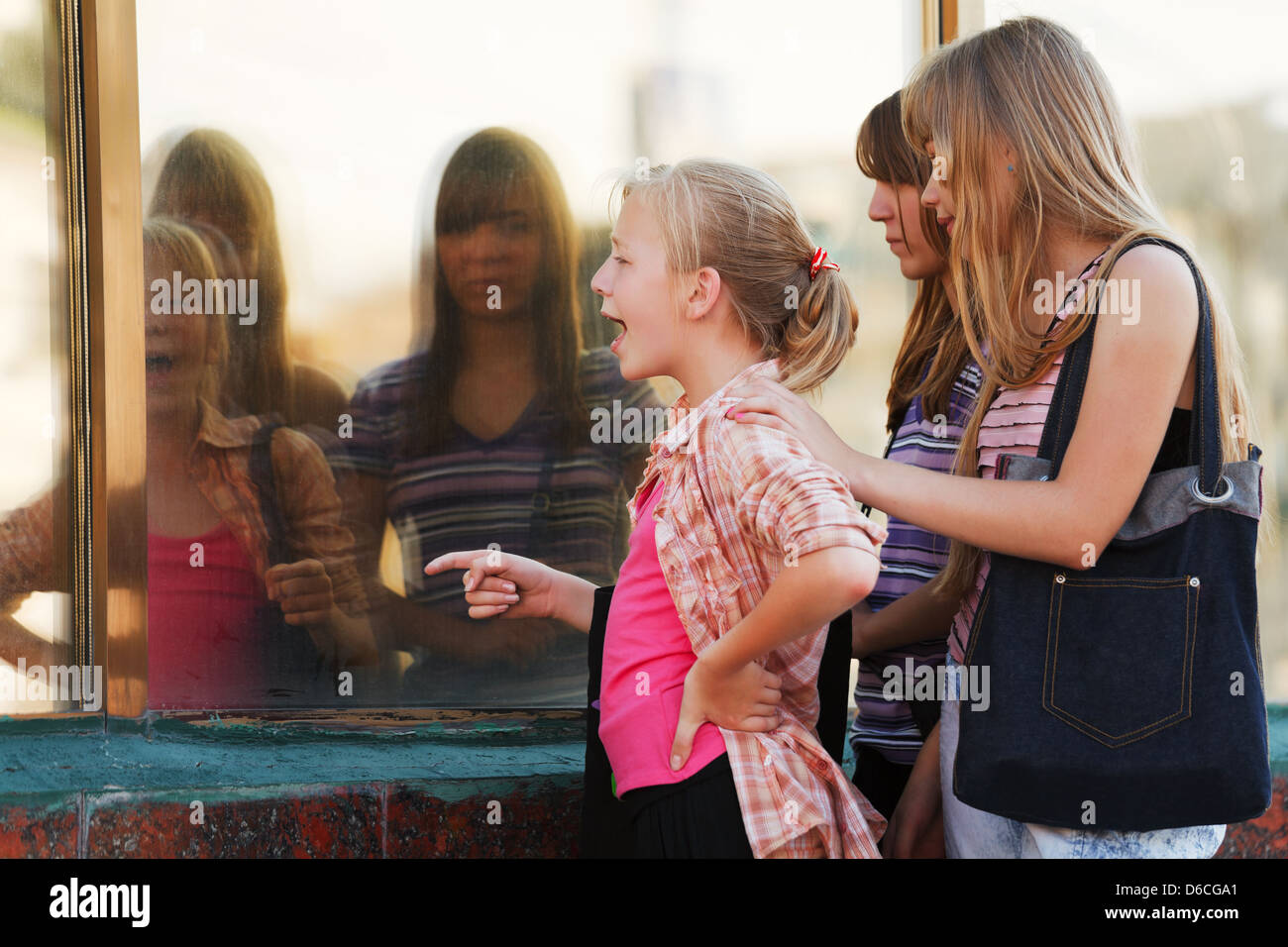 Schoolgirls looking through a shop window Stock Photo - Alamy