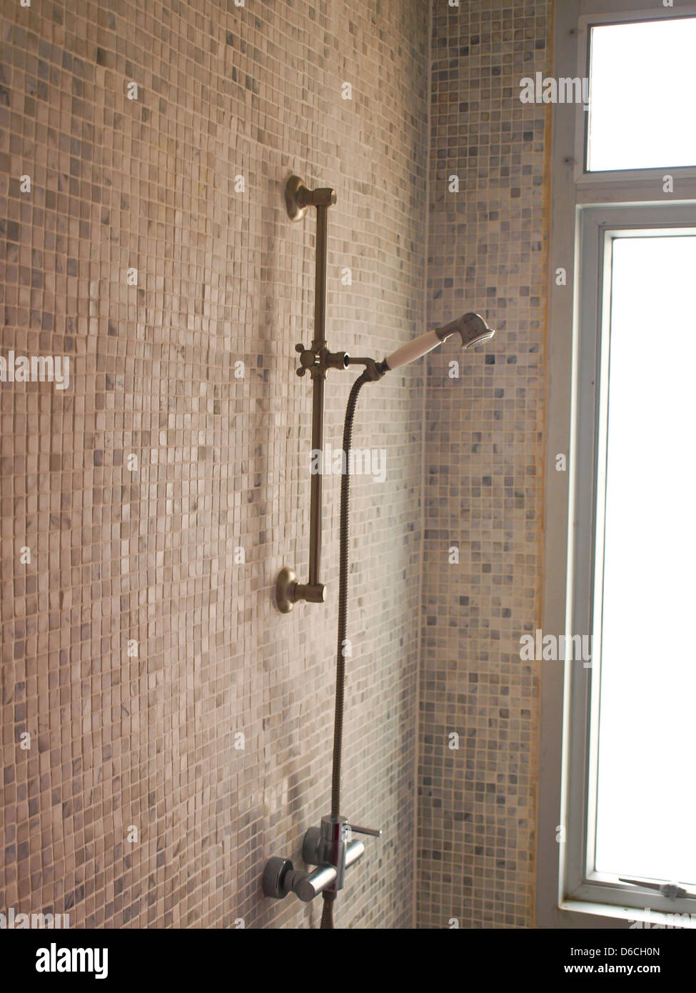 Modern shower faucet with light tiled wall and natural light Stock ...