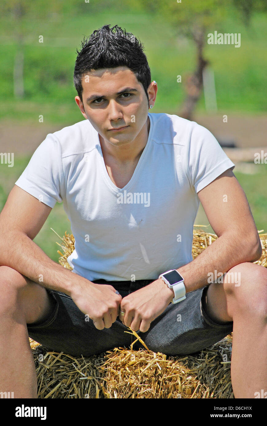 young man on hay bale Stock Photo - Alamy