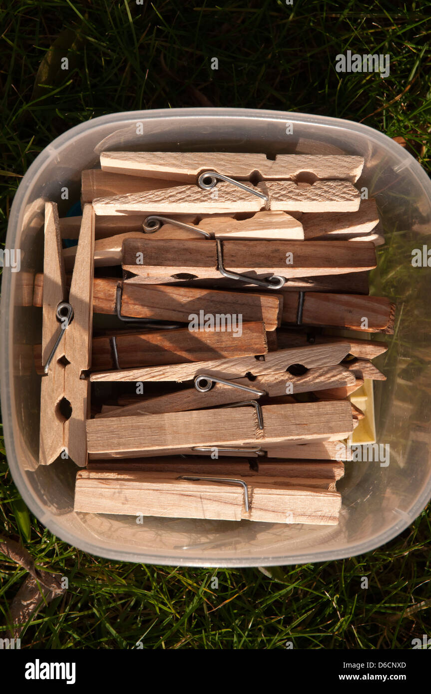 clothes pegs, wooden, in plastic container,grass background, semi close ...