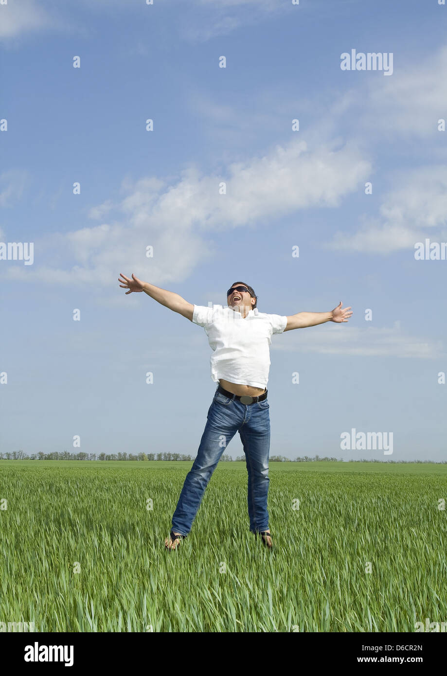 young man jumping a green field of grass Stock Photo - Alamy